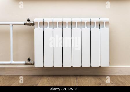 Modern water heating radiator attached to the wall under the window ...