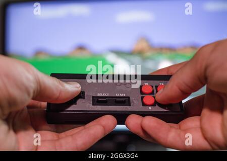 Male hands hold joystick video-game console next blue TV-screen with ...