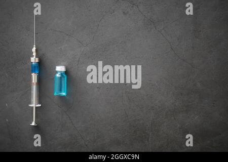 small jars with injection and syringe for injection on blue background ...