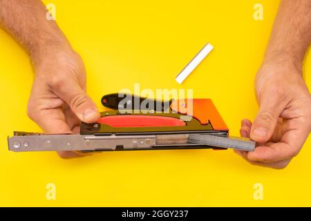 male hands fill the stapler gun with staples Stock Photo - Alamy