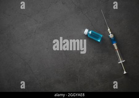 small jars with injection and syringe for injection on blue background ...