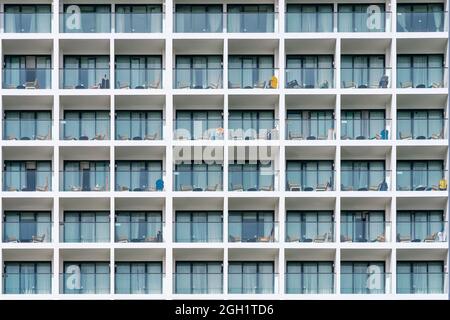 fragment of a facade of a building with balcony with table and chair ...