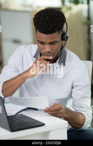 Young help desk operator working in office with many conflicting ...