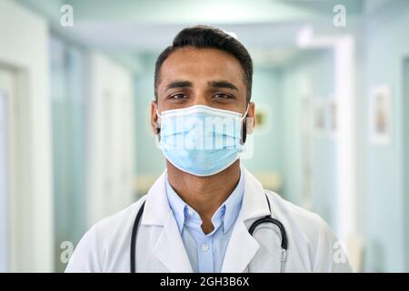A male cardiologist wearing a medical mask examines a male heart ...