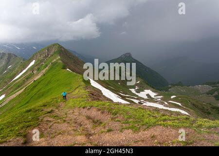 Tourist hiking to the top of the Talijanka peak (Maja e Vajushës peak ...