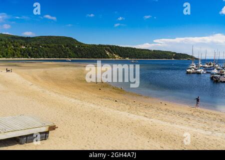 The sandy beach and marina of the Tadoussac Bay on a beautiful summer ...