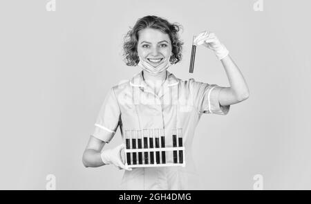 Technologist holding test results while his assistant opening bottle ...