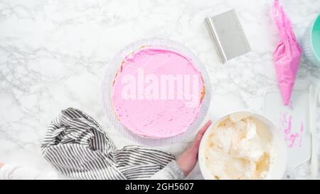 Flat lay. Step by step. Frosting round funfetti cake with white italian ...