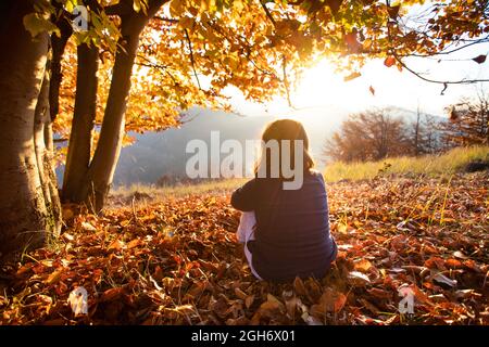 Little girl in magic autum landscape in the sunset. Enjoying, traveling ...