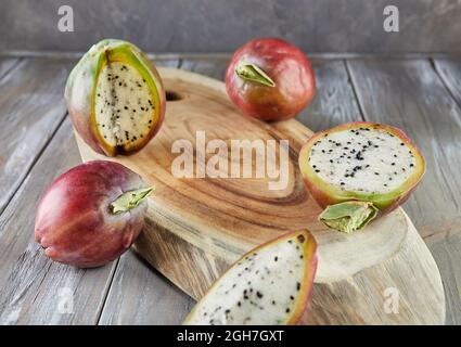 Peruvian apple cactus fruits whole and cut on wooden stand on gray ...