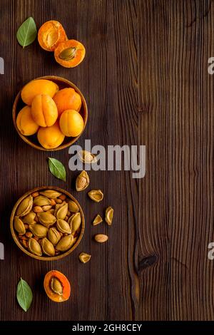Wooden bowls of apricots and apricot kernel almond, top view Stock ...