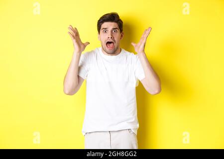 Frustrated and shocked guy panicking, screaming and looking scared ...