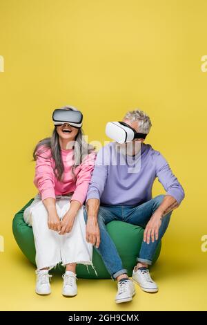 Happy middle aged woman with a VR headset on playing games and her ...