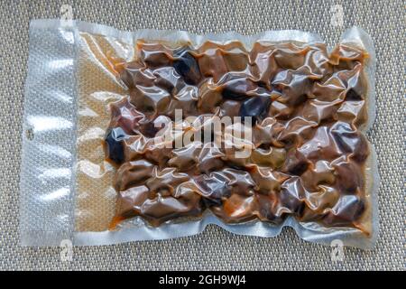 Greece olives in plastic pack, on black dark stone table background ...