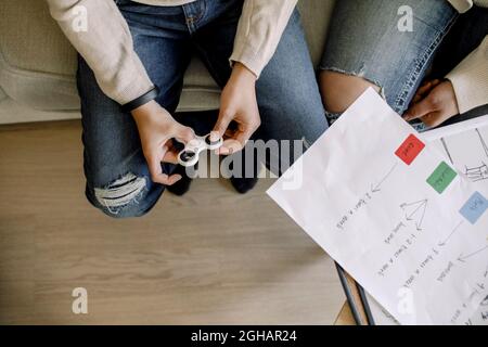 Above shot mixed race family sitting together doing homework and using ...