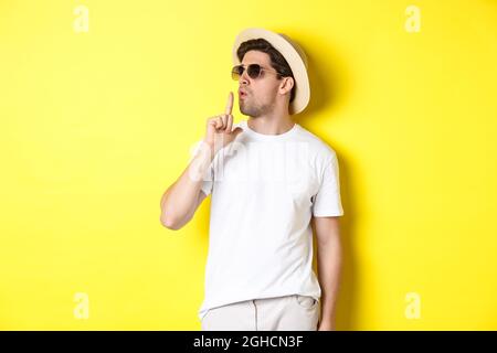Cool young male tourist blowing at finger gun and looking confident ...