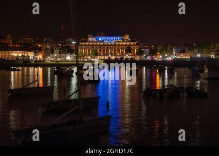 Cascais waterfront at night with illuminated buildings, boats, and ...