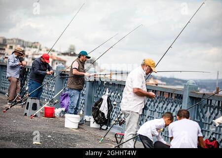 People are seen fishing on the Galata Bridge at noon. (Photo by Onur ...