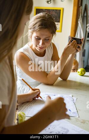 happy teen girl making notes in notebook sitting on grass. taking notes ...