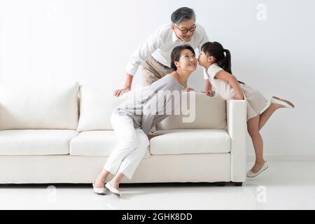 Grandparents kissing child while standing in kitchen Stock Photo - Alamy