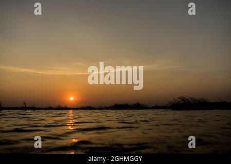 Beautiful view of the wavy lake gleaming under the shiny sunrays during ...