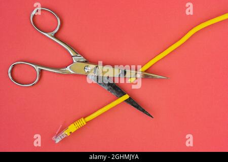 Scissors cutting the yellow network cable. Prohibit and restrict access ...