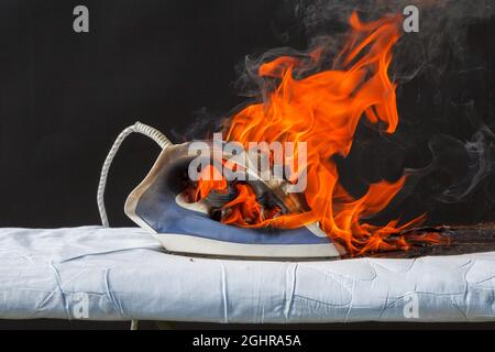 Iron in flames of fire, faulty wiring, cause of fire Stock Photo - Alamy