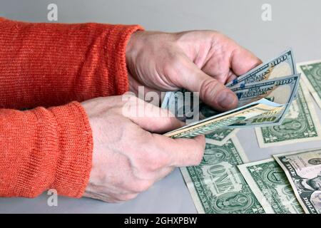 Caucasian man's hands counting dollar banknotes on gray surface. Male ...