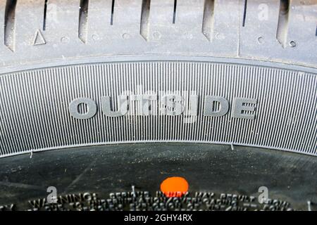 text on tire sidewall indicating direction for wearing the tires on the ...