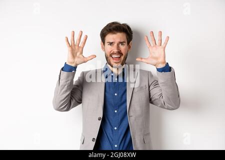 Frustrated man giving up, raising hands up in surrender and screaming ...