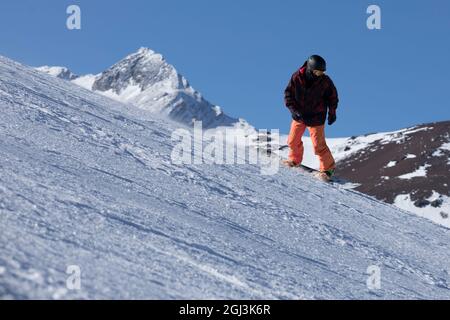 man snowboarding down by hill mountains on background sunny day Stock ...