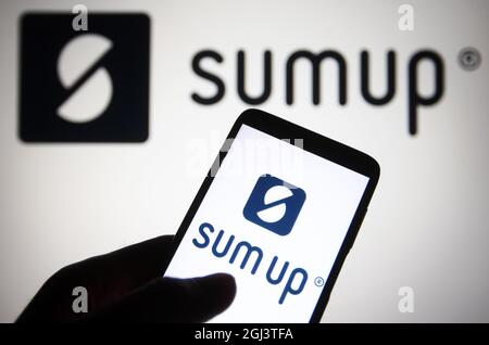 The logo of SumUp is seen on a screen of a smartphone next to an ...