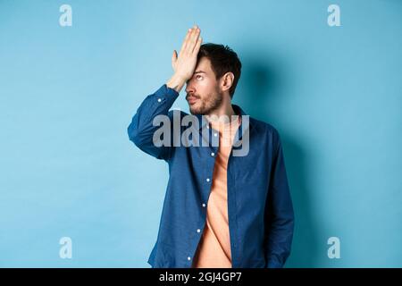 Annoyed and tired man facepalm, roll eyes and look bothered by stupid ...