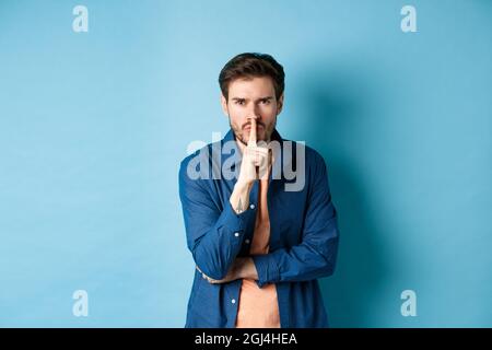 Be quiet. Angry man frowning and shushing, telling to calm down, press ...