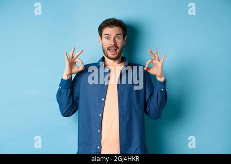 Impressed man praising something awesome, showing okay signs and ...