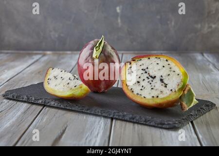 Peruvian apple cactus fruits whole and cut on wooden stand on gray ...