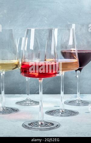 Rose wine in different glasses on light concrete background. Minimal ...