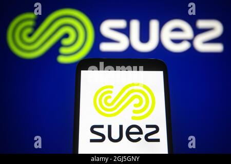 In this photo illustration, SUEZ logo is seen on a smartphone and a pc ...