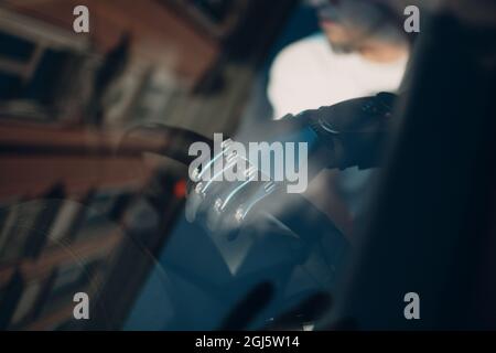 Young disabled man driver with artificial prosthetic hand driving ...