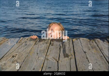 Wooden bridge above water with people walking Stock Photo - Alamy
