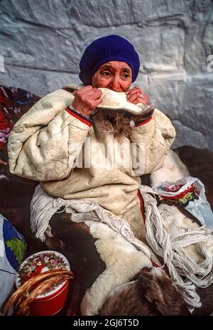 Inuit woman wearing traditional caribou skin clothing demonstrates ...