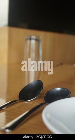 Vertical shot of wooden spoons beside mortar and pestle isolated on a ...