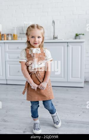 girl with flour stains on apron standing in kitchen Stock Photo - Alamy