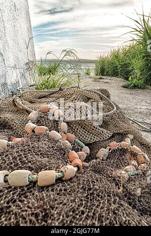 Fishing nets collected on sand beach. big bale of fishing nets. nylon ...