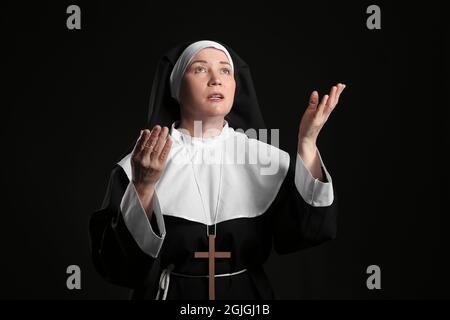 Upset mature nun on dark background Stock Photo - Alamy