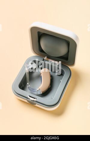 Box with hearing aid on color background Stock Photo - Alamy