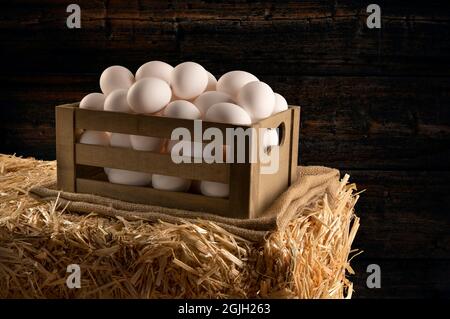 Eggs in a heap of Hay on wooden table Stock Photo - Alamy