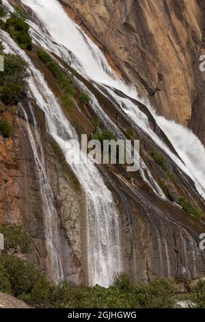 The river flows abruptly into a small lake and over a drop, creating a ...