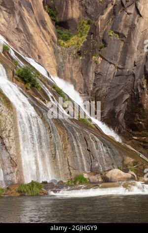 The river flows abruptly into a small lake and over a drop, creating a ...