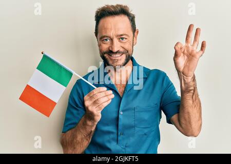 Middle age man holding ireland flag smiling with an idea or question ...